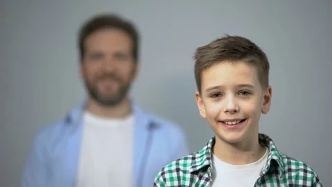 Boy smiling at camera, father standing o... | Stock Video | Pond5