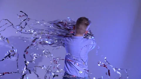 Boy spinning around with tinsel on gray ... | Stock Video | Pond5