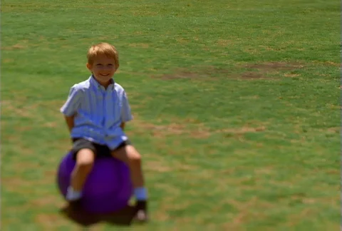 A boy successfully bouncing on a large b... | Stock Video | Pond5