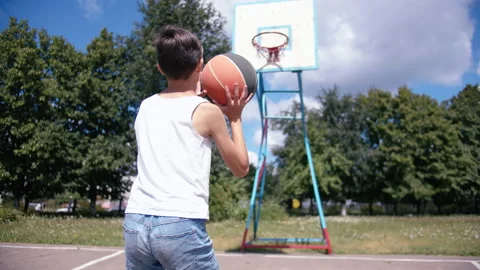 Boy throws the ball into the basketball ... | Stock Video | Pond5