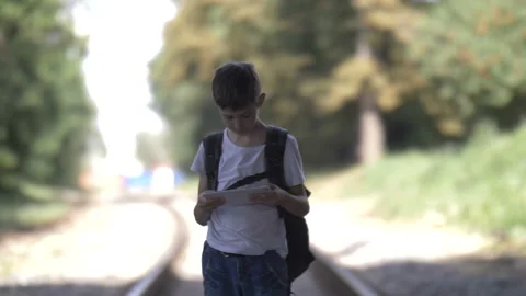 boy traveler looks at the map on the tab... | Stock Video | Pond5