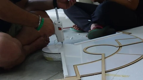 Boy using a glue gun to paste model. | Stock Video | Pond5