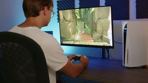 Boy walking to his gaming setup to pick ... | Stock Video | Pond5