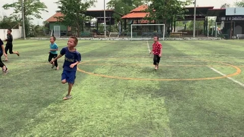 Boys running chasing a friend on artific... | Stock Video | Pond5