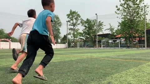 Boys running chasing a friend on artific... | Stock Video | Pond5