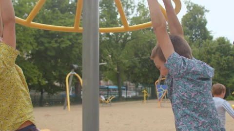 Boys spinning on the playground. Develop... | Stock Video | Pond5