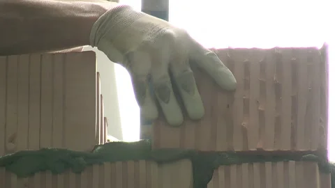 Bricklayer putting a big brick in a wall | Stock Video | Pond5