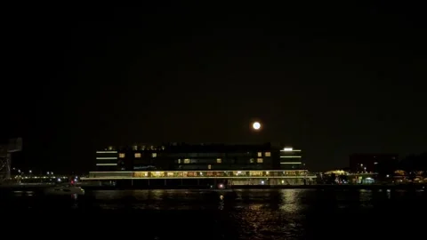 A brightly lit building by the water und... | Stock Video | Pond5