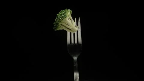 Broccoli on a fork rotates on a black ba... | Stock Video | Pond5