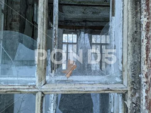 Broken glass windows of an old and destroyed building in the winter ...