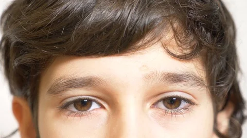 The brown eyes of a boy with long black ... | Stock Video | Pond5