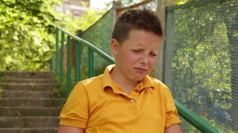 A bruised boy in a yellow shirt crying. | Stock Video | Pond5