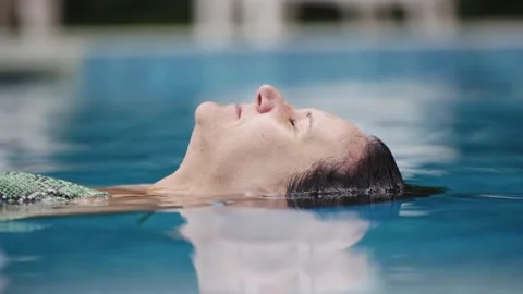 Brunette woman peacefully floating lying... | Stock Video | Pond5