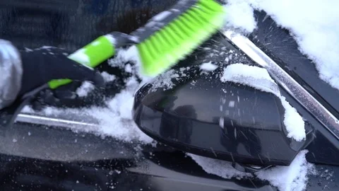 Brushing off snow from the side of a car | Stock Video | Pond5