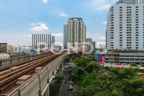 Photograph: BTS Skytrain rails, overhead bridge with buildings around ...