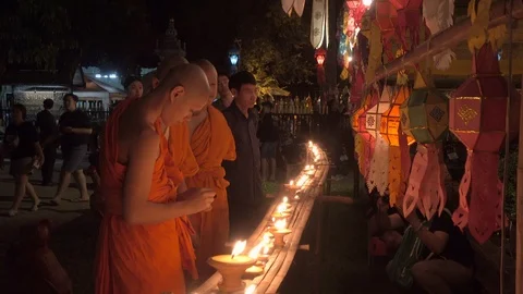 Buddhist monk fire candles to the Buddha... | Stock Video | Pond5