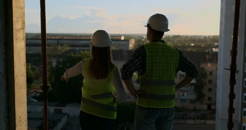 Builders look at a cityscape on a sunset... | Stock Video | Pond5