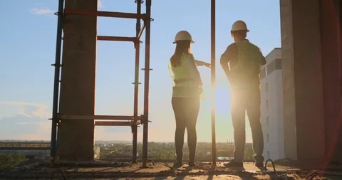 Builders look at a cityscape on a sunset... | Stock Video | Pond5
