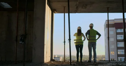 Builders look at a cityscape on a sunset... | Stock Video | Pond5