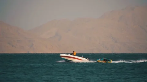 Bumper Tube Ride behind the Boat on Red ... | Stock Video | Pond5