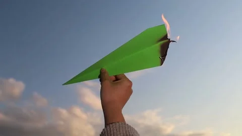 A burning paper airplane in the backgrou... | Stock Video | Pond5