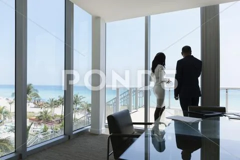 Business people looking out conference room window Stock Photo #53457680