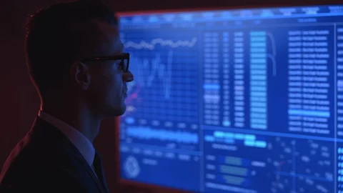 The businessman looks on blue monitors i... | Stock Video | Pond5