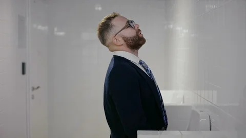 Businessman urinating in office toilet. | Stock Video | Pond5