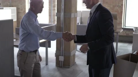 Businessmen shaking hands in new open pl... | Stock Video | Pond5