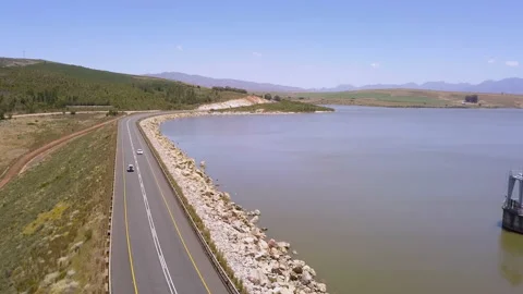 Car driving across a dam wall, dam full ... | Stock Video | Pond5