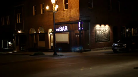 Car driving by a bar late at night | Stock Video | Pond5