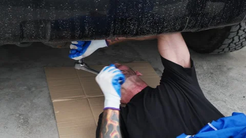 A car mechanic laying down on the ground... | Stock Video | Pond5