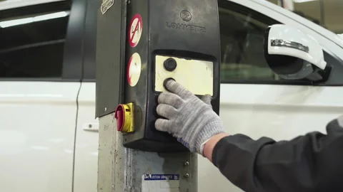 The car mechanic presses a button on the... | Stock Video | Pond5