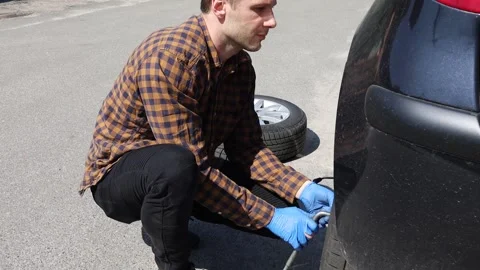 A Car Mechanic Using A Jack To Change A ... | Stock Video | Pond5