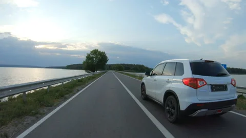 Car riding through road near lake. White... | Stock Video | Pond5