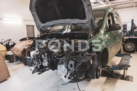 A car without the front and without the hood is standing in a garage ...