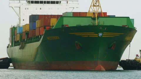 Cargo ship assisted by two tug boats and... | Stock Video | Pond5