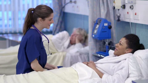 Caring nurse chats with a female patient... | Stock Video | Pond5