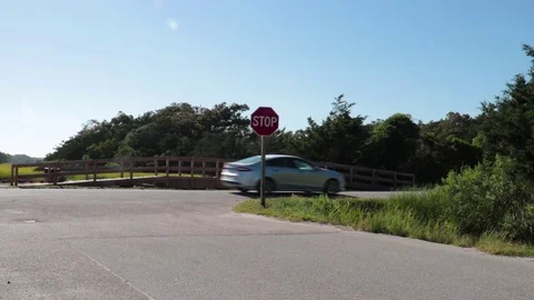 Cars Driving by a Stop Sign in Front of ... | Stock Video | Pond5