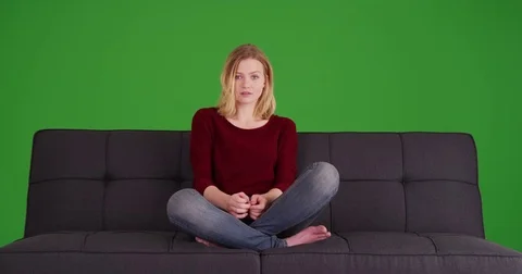 Casual young blonde woman sitting on sof... | Stock Video | Pond5