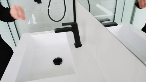 Caucasian woman turning on water in mode... | Stock Video | Pond5