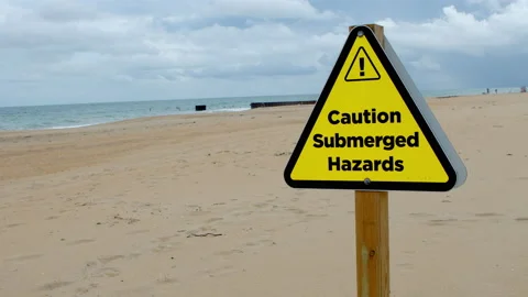 Caution Submerged Hazards Sign at Beach | Stock Video | Pond5