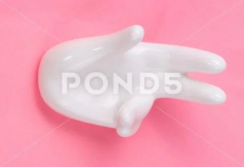 Ceramic stand with hand shape on pink background ~ Hi Res #77617828