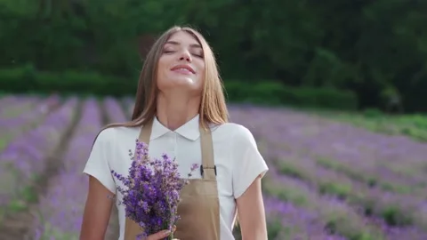 Charming girl smelling scent of lavender... | Stock Video | Pond5