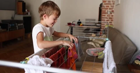 Cheerful little boy drying clothes on st... | Stock Video | Pond5
