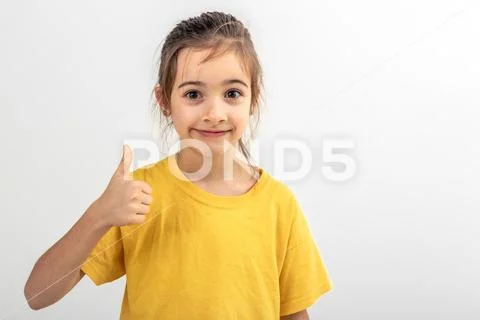 Cheerful little girl showing finger thumb up isolated on white ...