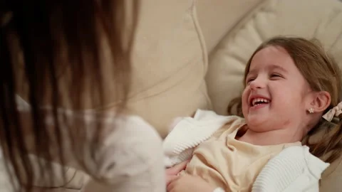 Cheerful mother tickles daughter plays w... | Stock Video | Pond5