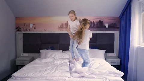 Cheerful twins jumping on bed | Stock Video | Pond5
