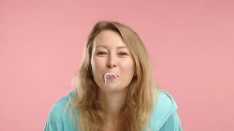 Cheerful Young Woman Chewing Gum and Blo... | Stock Video | Pond5