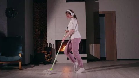 Cheerful young woman dancing with a mop ... | Stock Video | Pond5